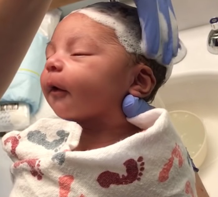 Newborn baby gets her first shampoo