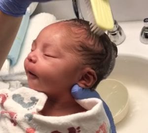 Newborn baby gets her first shampoo