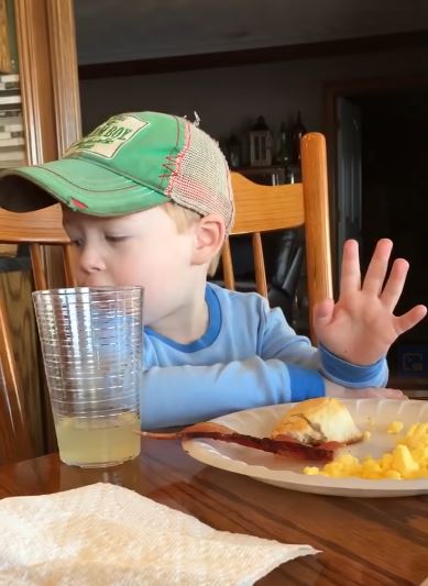 Funny little boy shows how to give directions in the country