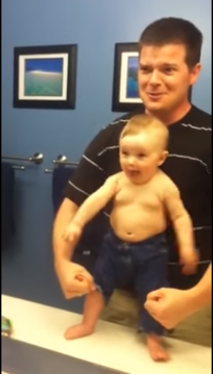 Baby and dad have adorable muscle flexing contest in the mirror