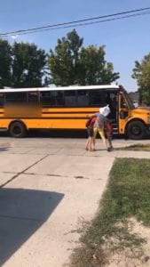 Mom waits for school bus in her best outfit